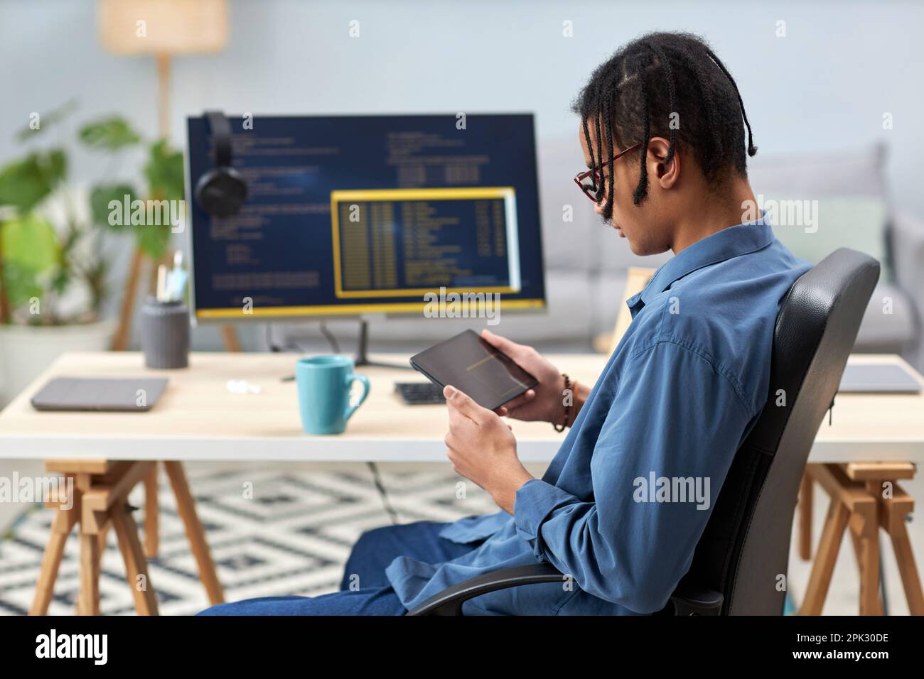 Side view of male IT programmer holding tablet and writing code for ...