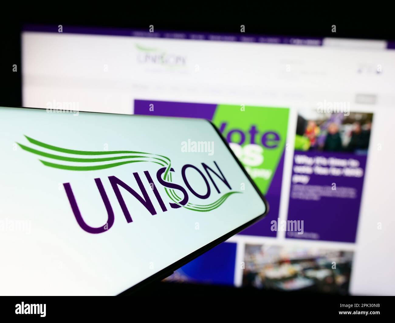 Mobile phone with logo of British trade union UNISON on screen in front ...