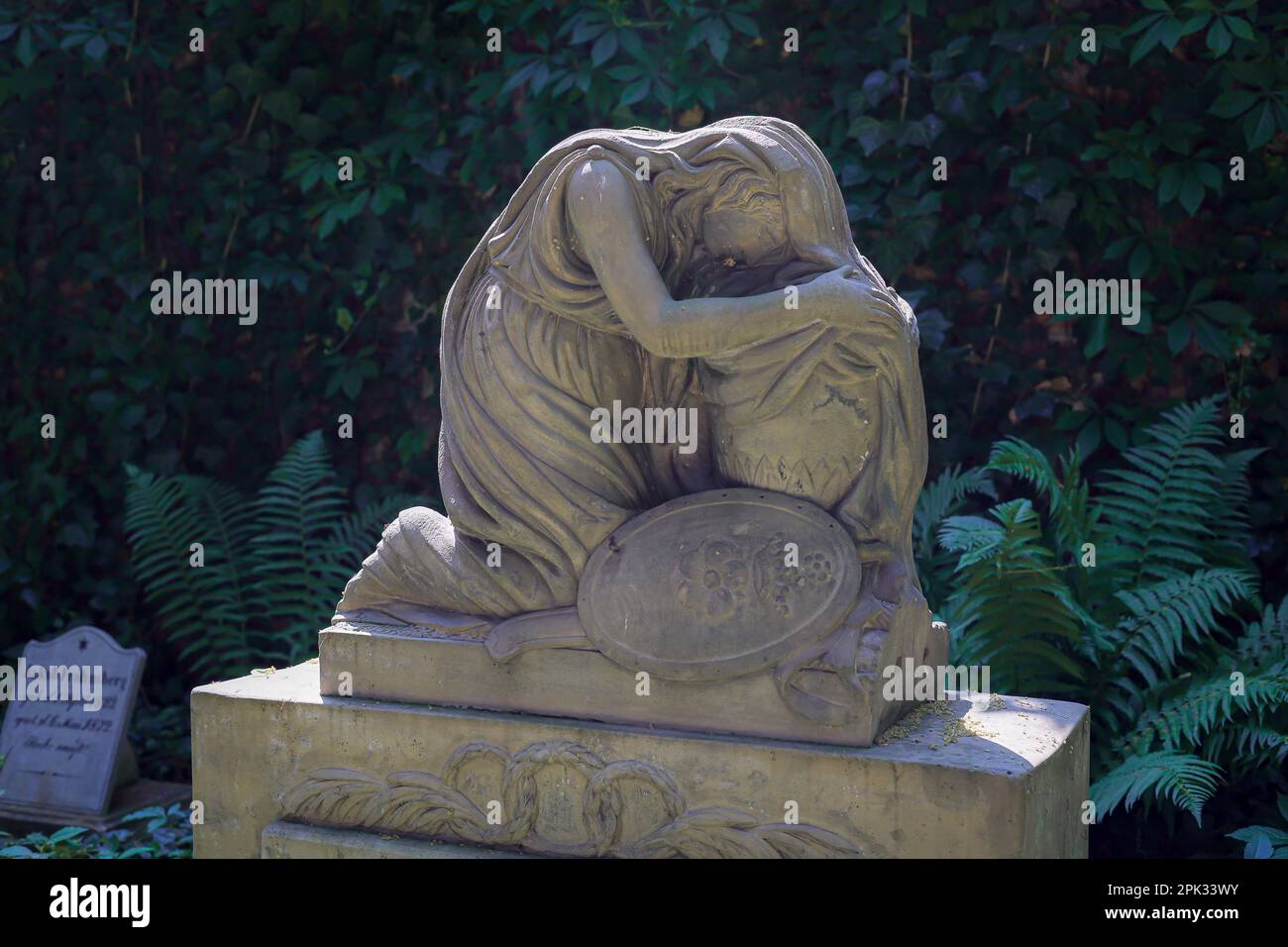 A statue of a human figure atop a pedestal with one hand gently ...