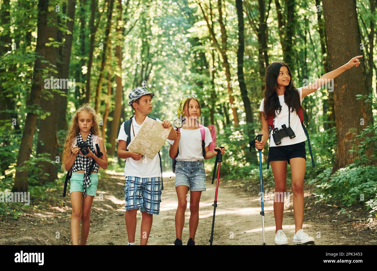 With map. Kids strolling in the forest with travel equipment Stock ...