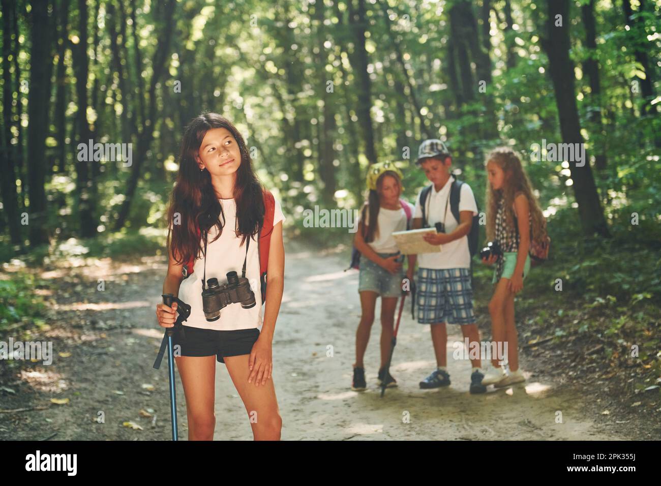 Front view. Kids strolling in the forest with travel equipment Stock ...