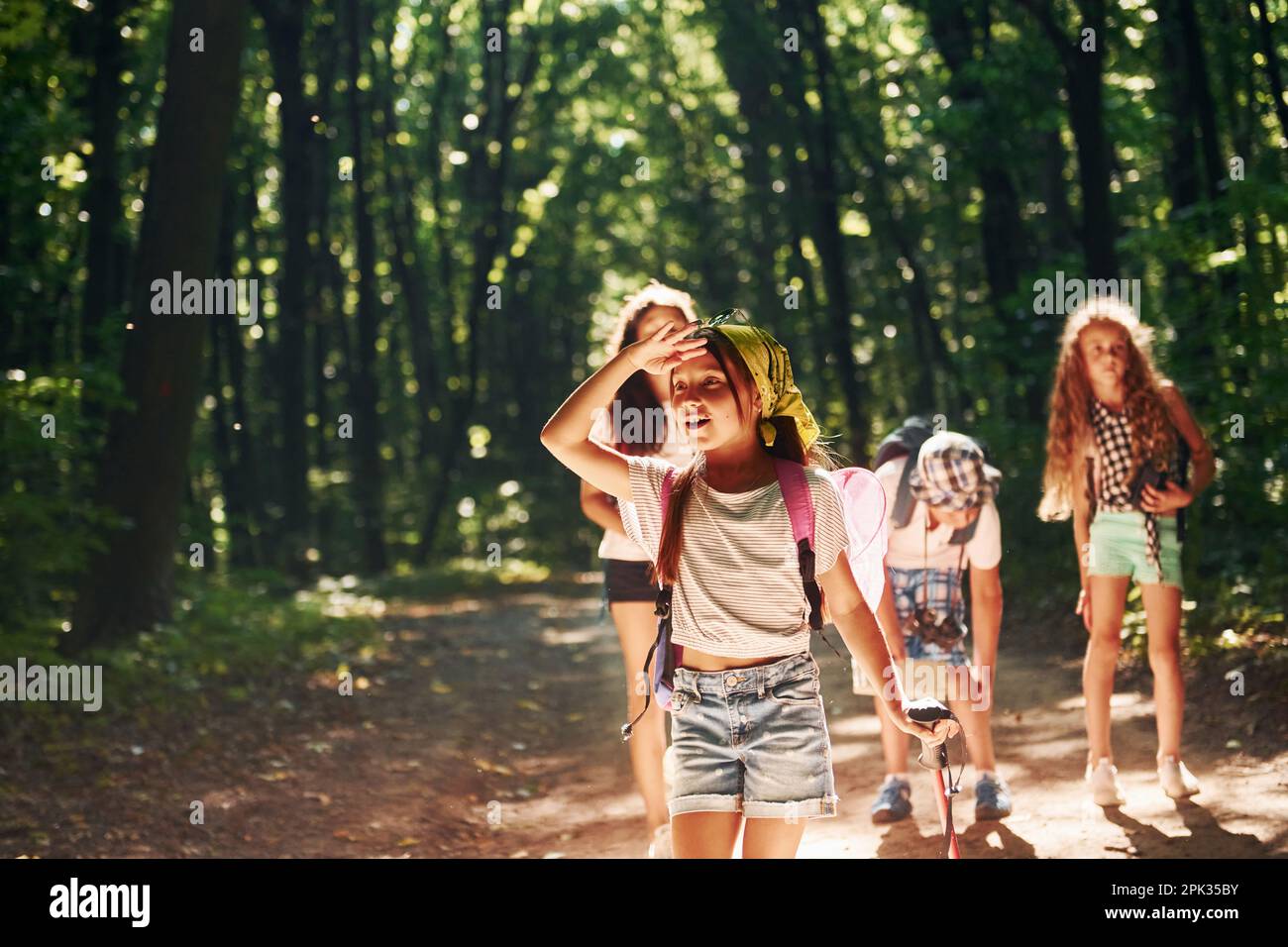 Girl looking far away. Kids strolling in the forest with travel ...