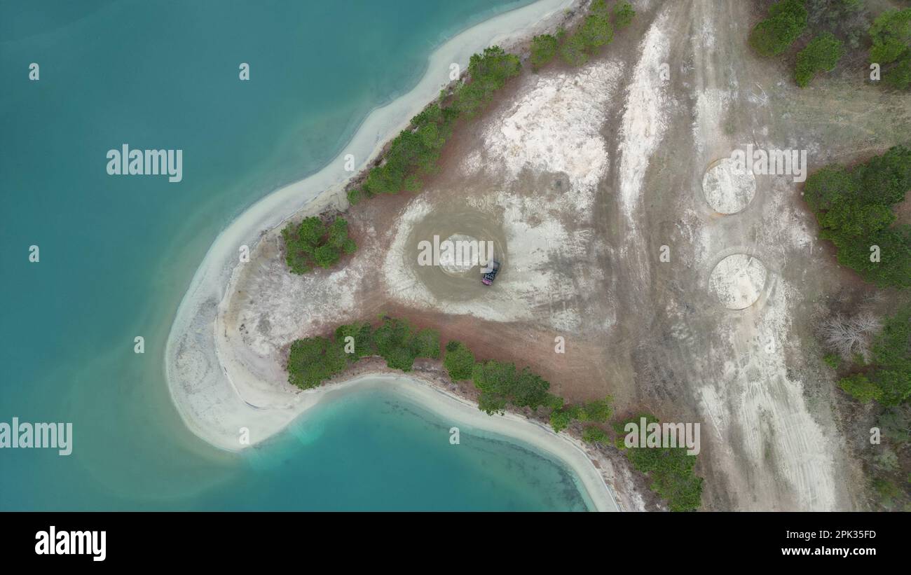 An island in the middle of the water with sand around it Stock Photo ...