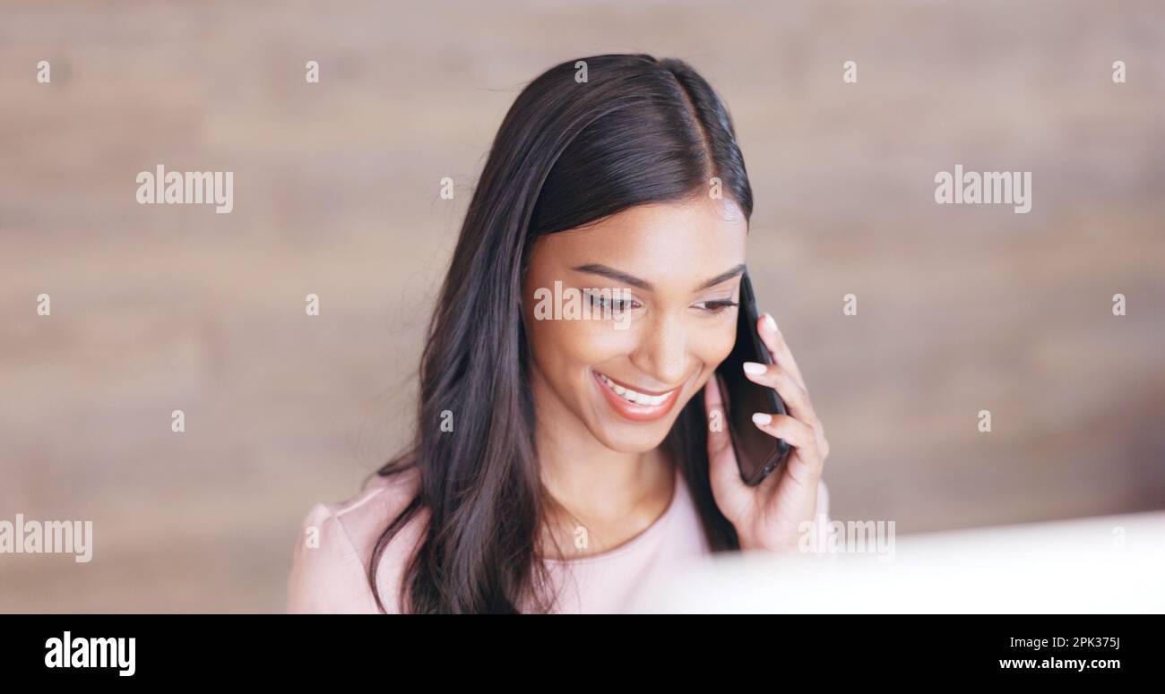 Secretary talking on a phone while working on a computer at a front ...