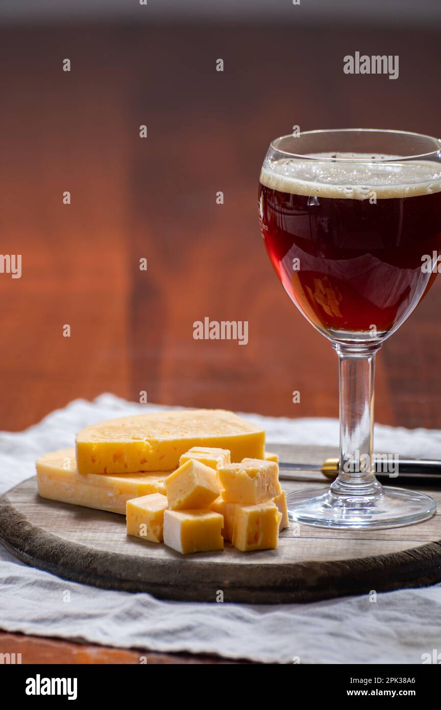 Glass of Belgian abbey brown beer in glass and wooden board with ...