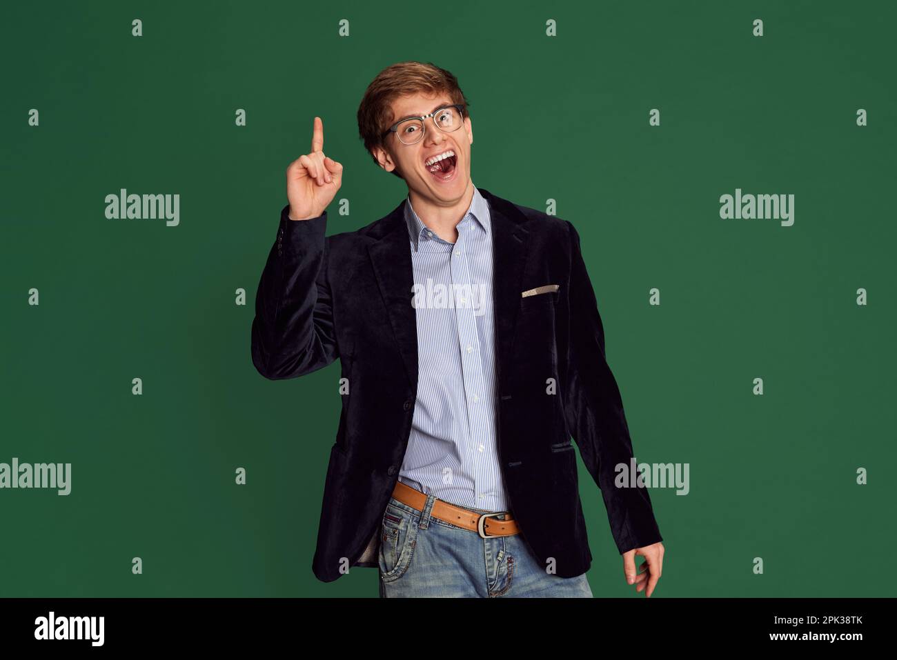 Portrait of happy, delightful young man, employee raising finger ...