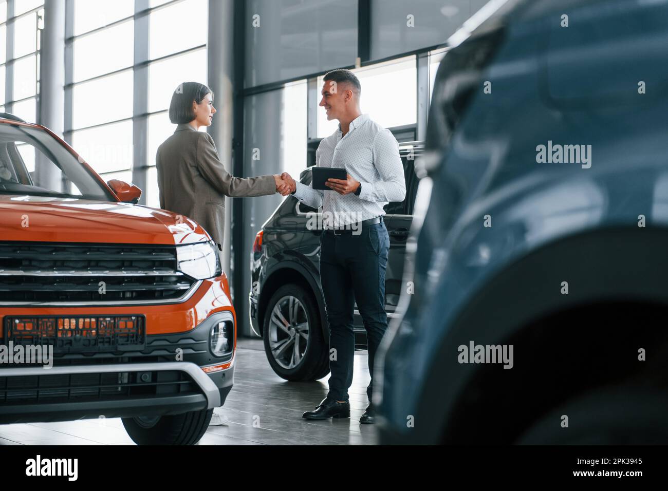 Making agreement. Man in formal wear helping customer with choice of ...