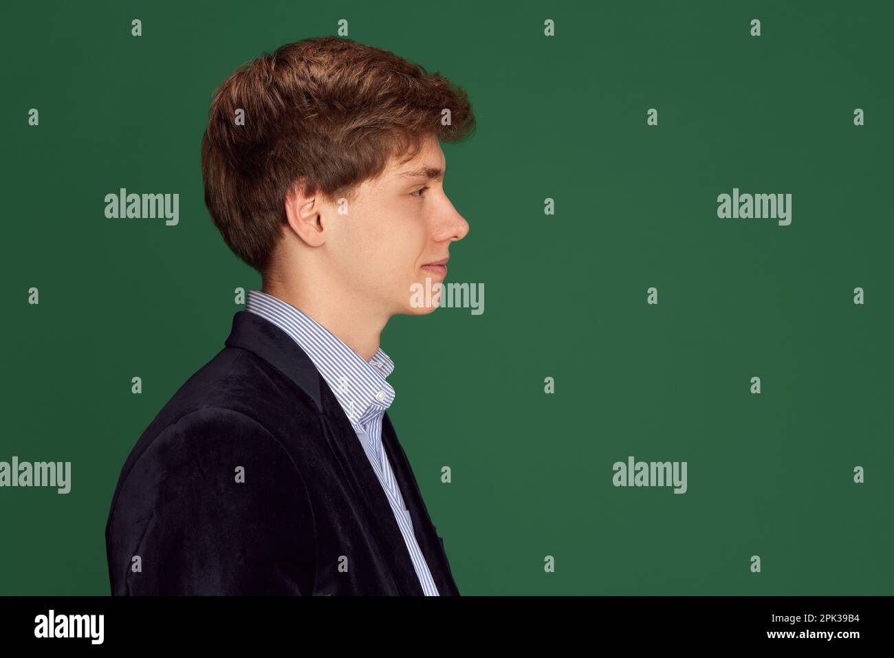 Side view image of young man in formal jacket looking straight, posing ...