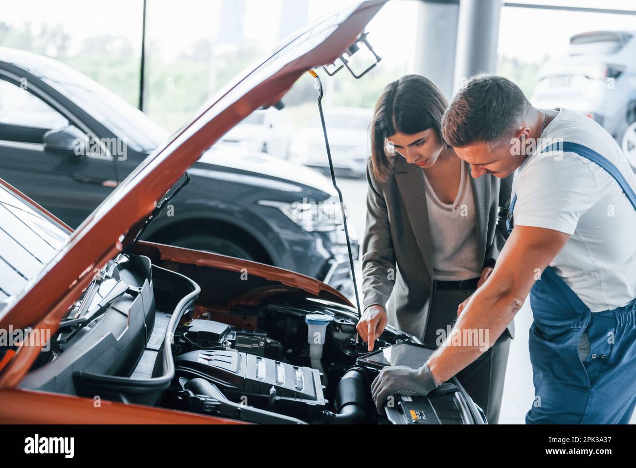 Showing results of work. Man repairing woman's automobile indoors ...
