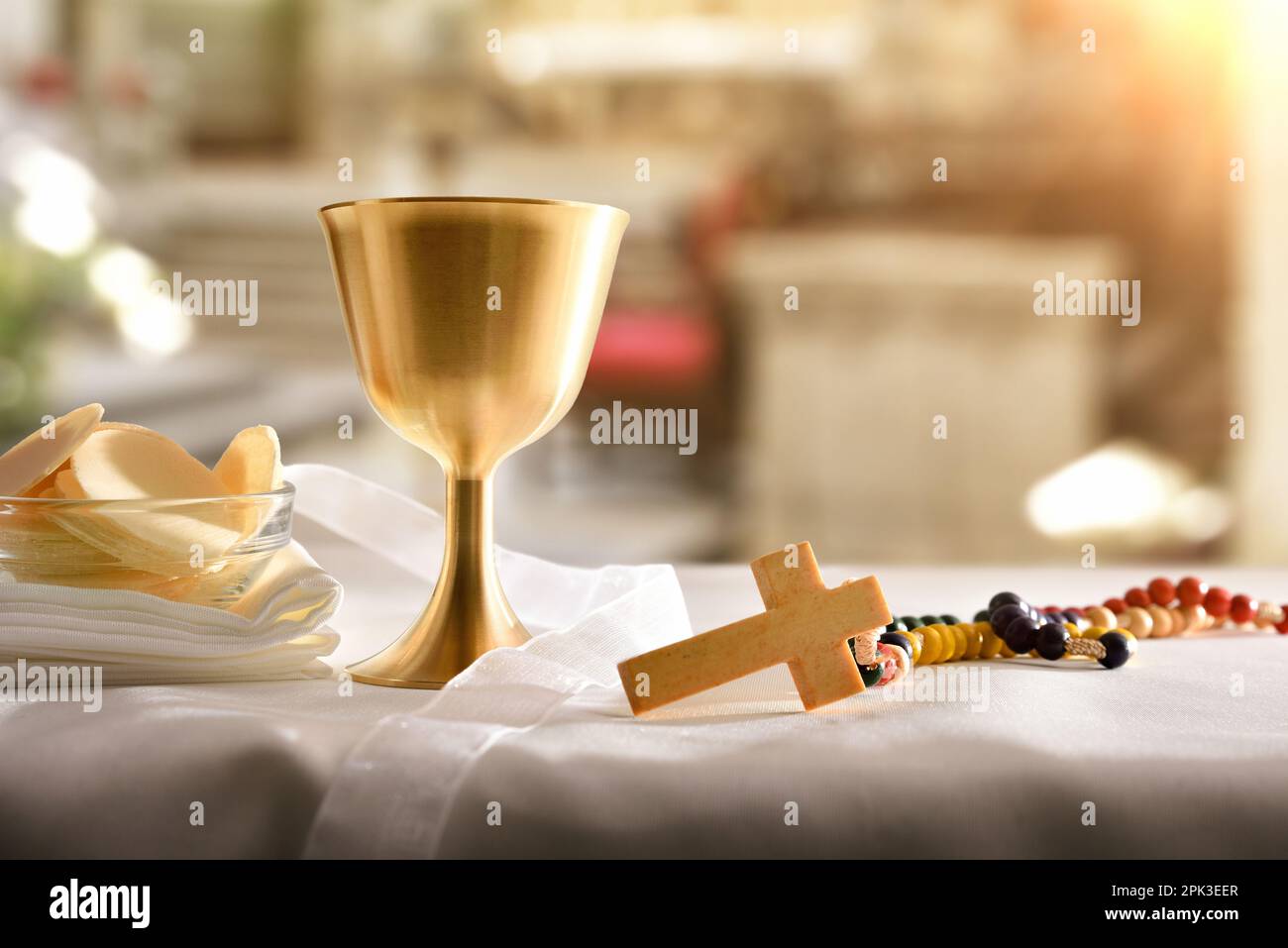 Chalice cup with wine and consecrated hosts in a container on table ...