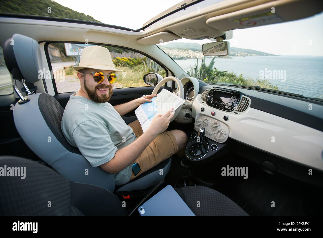 Hipster man looking on location navigation map in car, tourist traveler ...