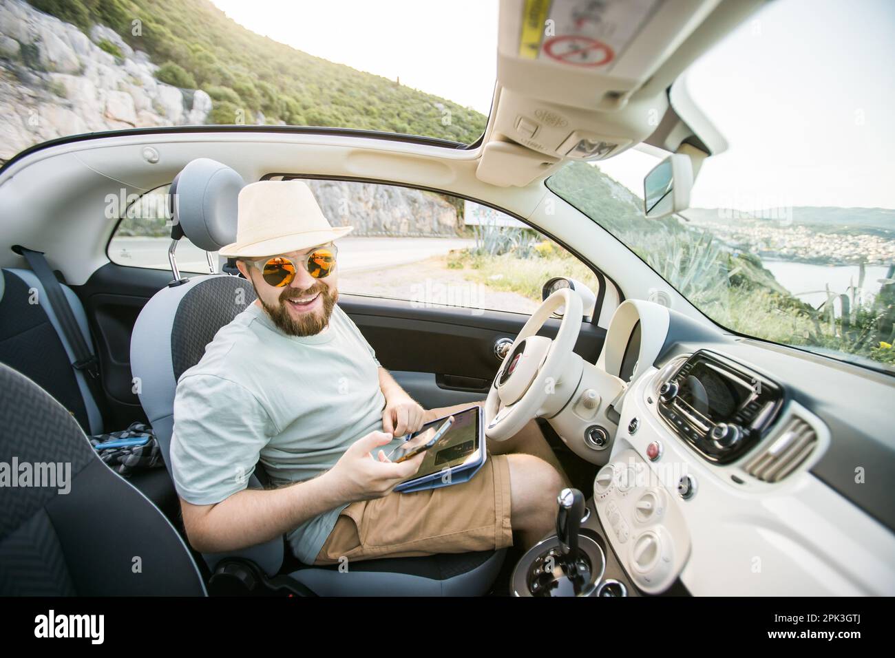 Hipster man looking on location navigation map in car, tourist traveler ...