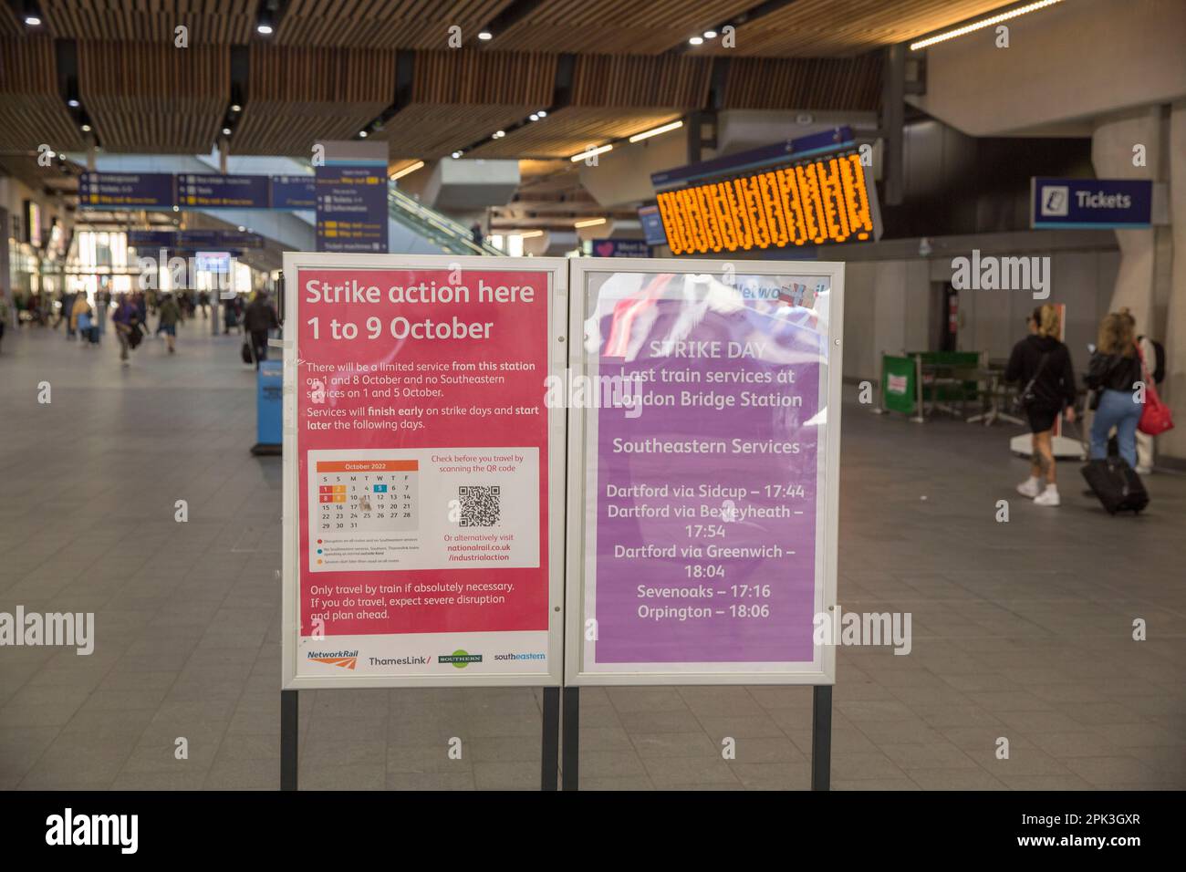 People walk past an information board informing passengers of the ...