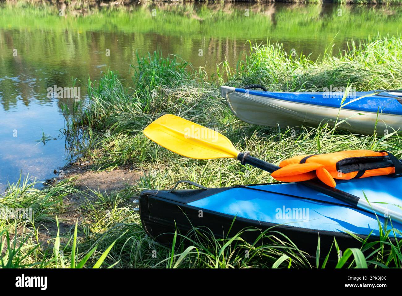 Tourist Canoes With Paddles Stand On The River Coast In Summer On A