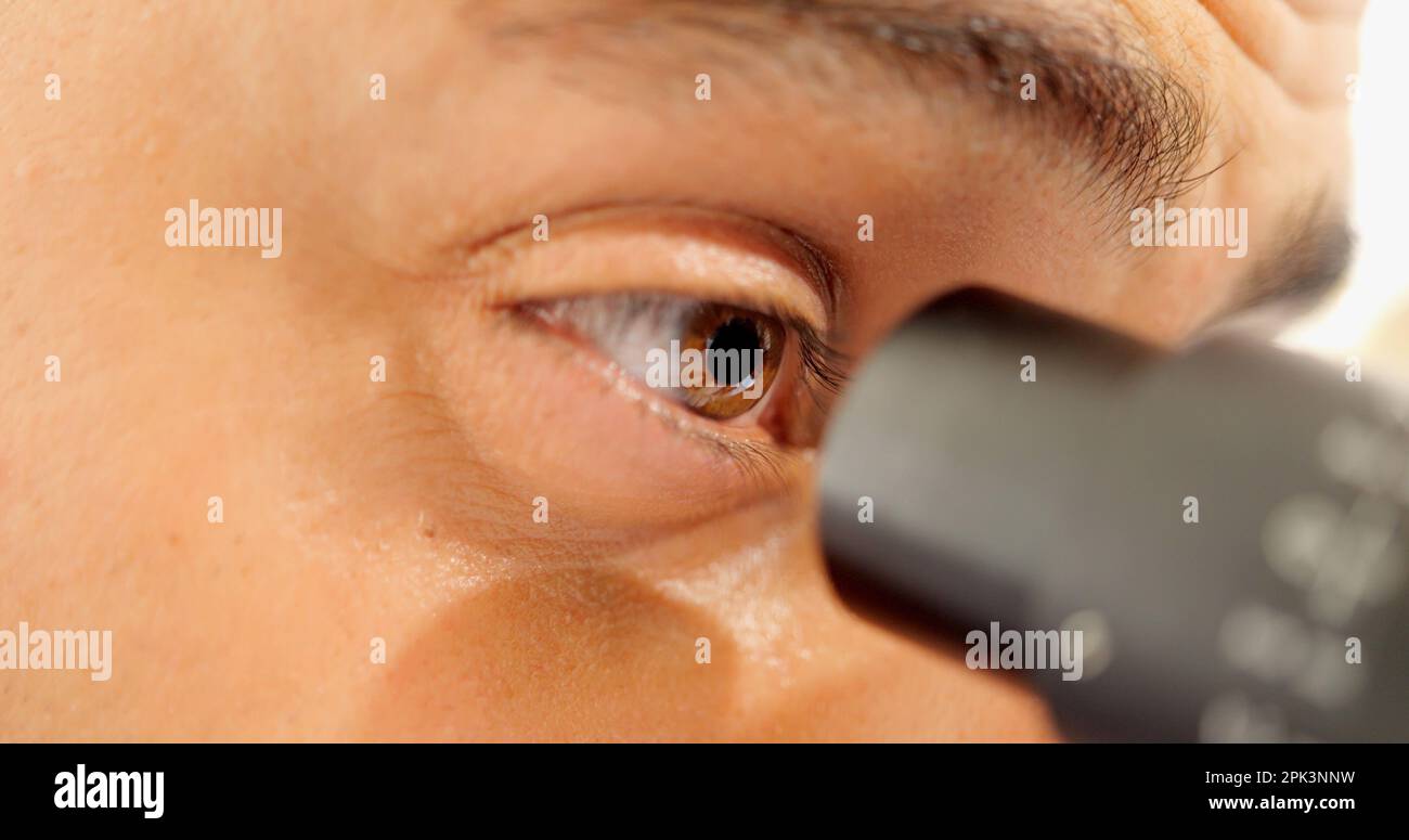 Eye of professional male scientist looking through microscope in ... Eye of professional male scientist looking through microscope in ...