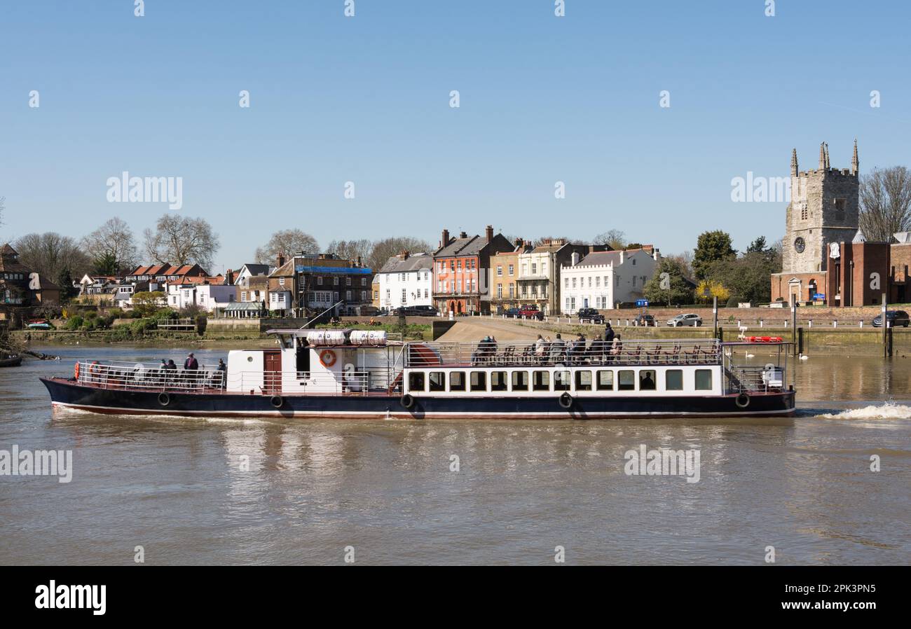 A pleasure cruiser on the River Thames passing in front of All Saints ...