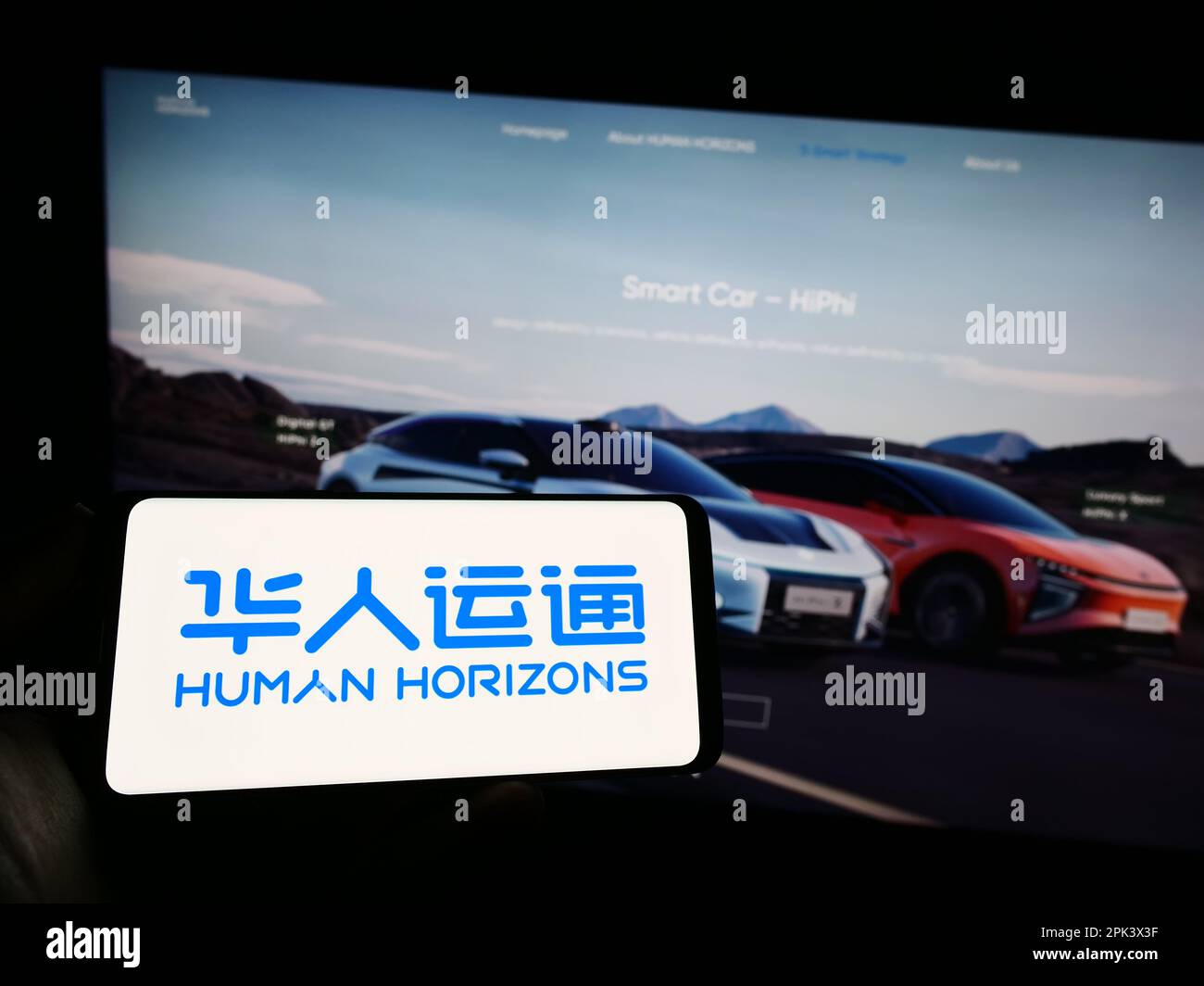 Person holding mobile phone with logo of Chinese company Human Horizons ...