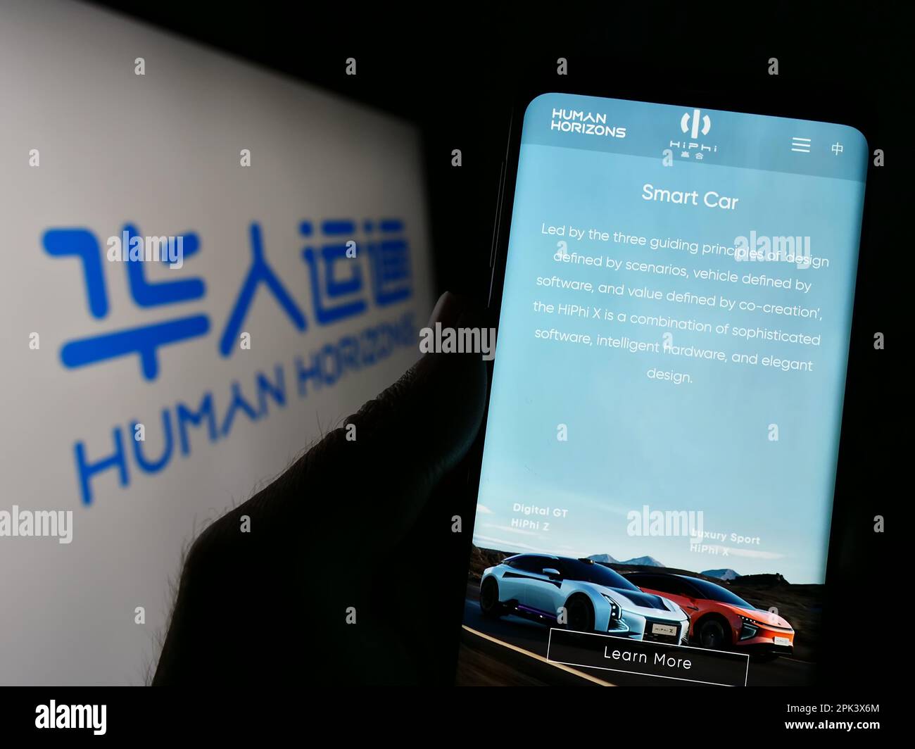 Person holding cellphone with website of Chinese company Human Horizons ...