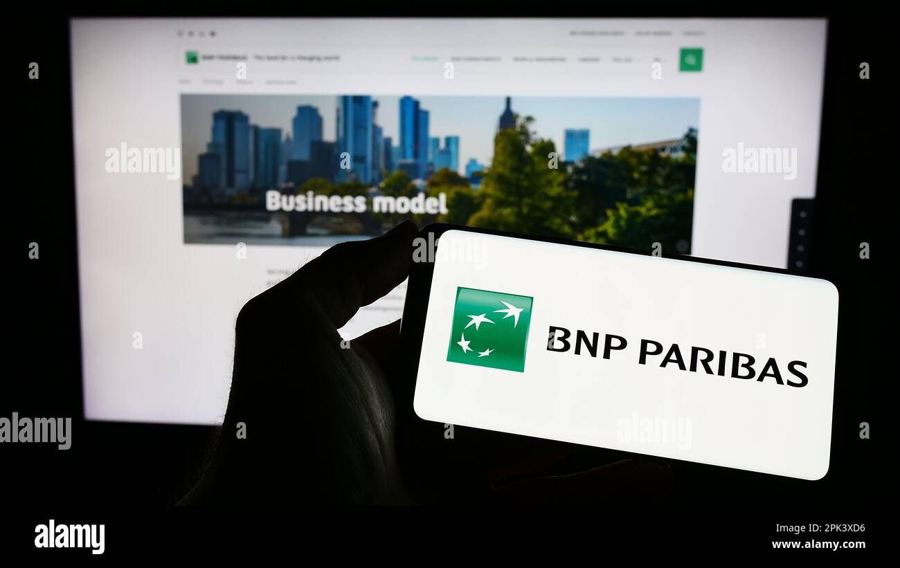Person holding cellphone with logo of French banking company BNP ...