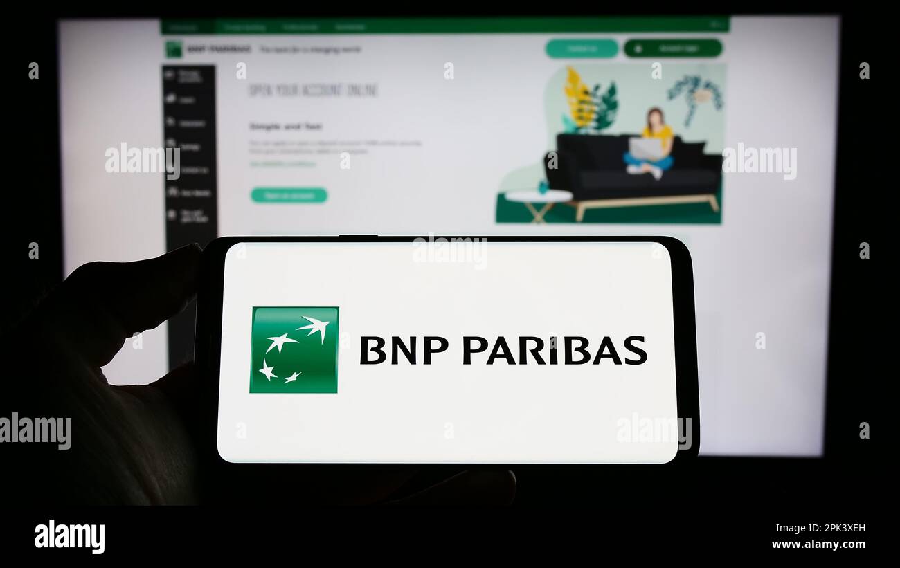 Person holding smartphone with logo of French banking company BNP ...