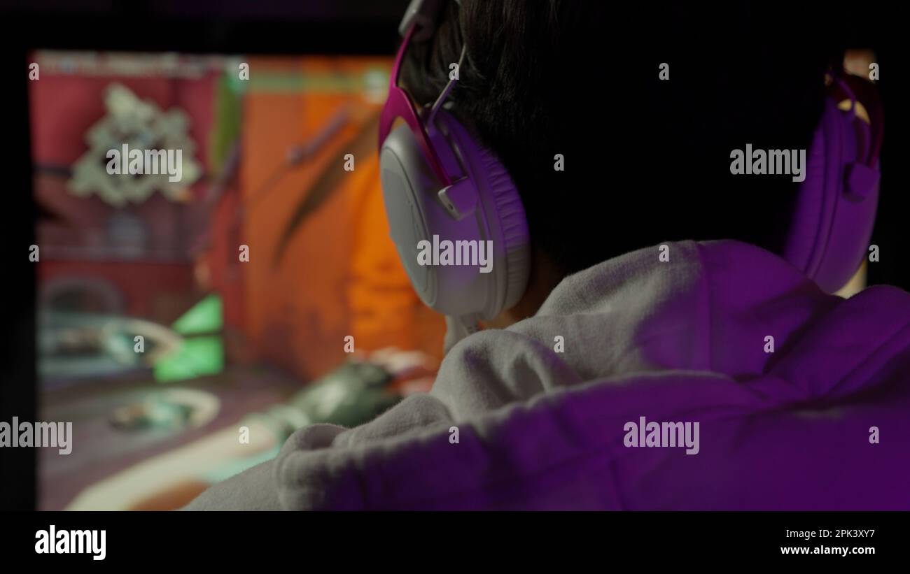 Game streamer using pc setup playing multiplayer first person shooter ...