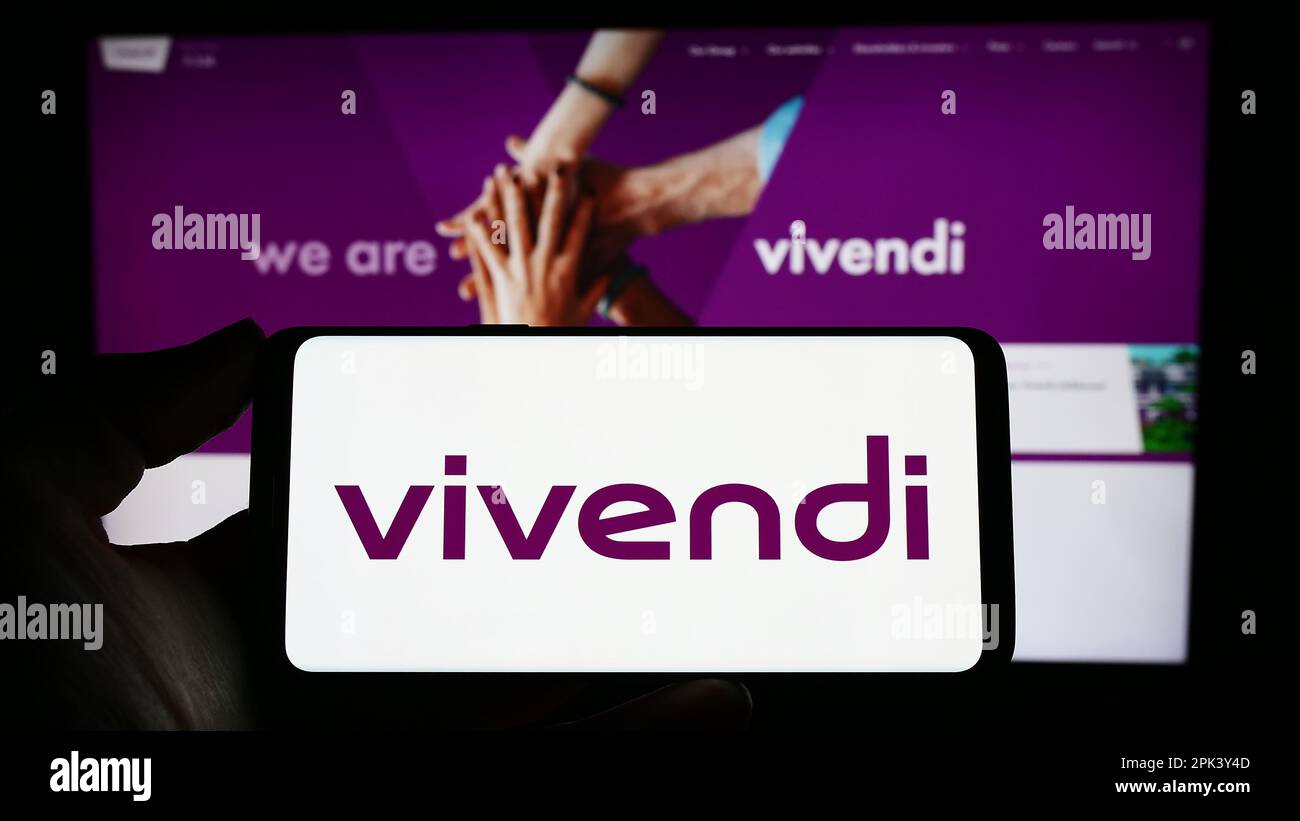 Person holding smartphone with logo of French mass media company ...