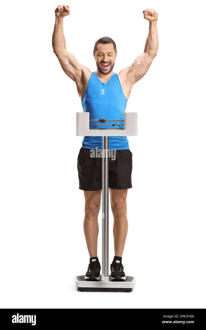 Excited young man weighing on a medical scale and gesturing happiness ...