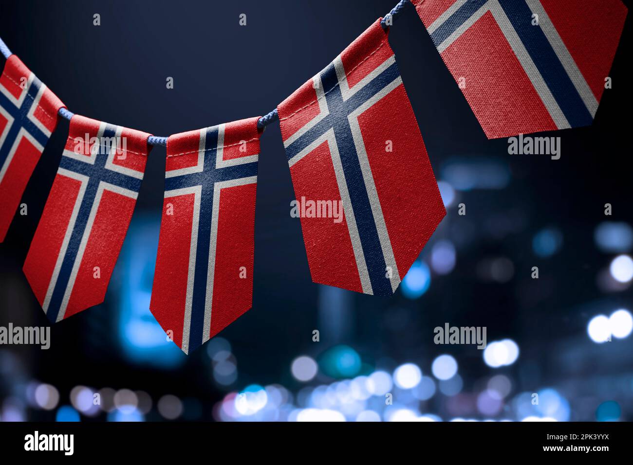 A garland of Norway national flags on an abstract blurred background ...