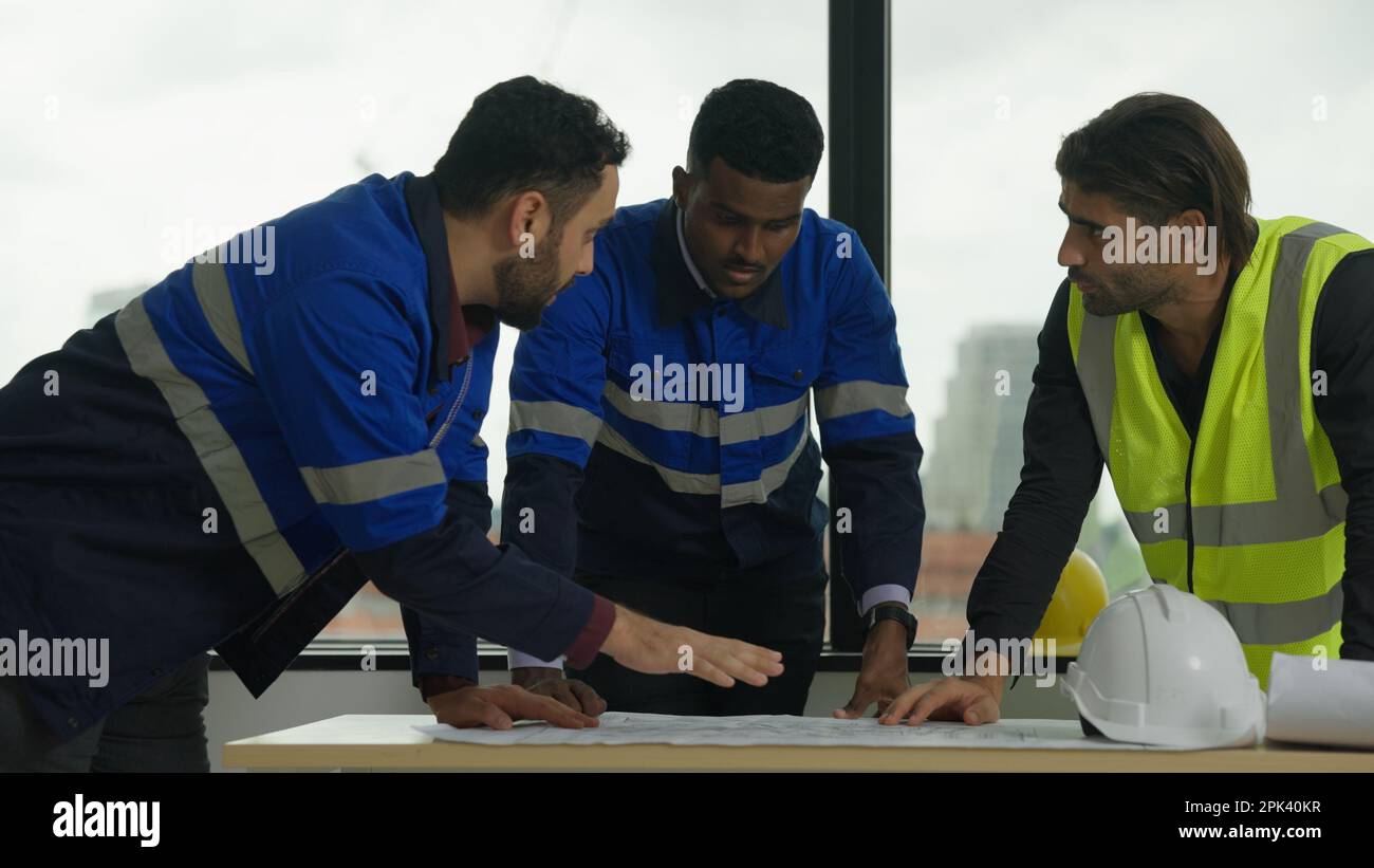 Construction engineers team using blueprint of project plan ...