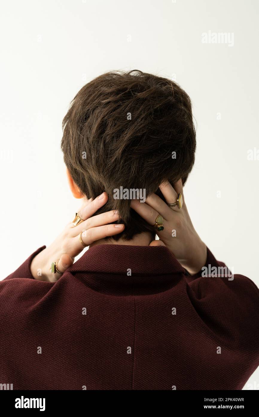 back view of brunette short haired woman in finger rings posing with ...