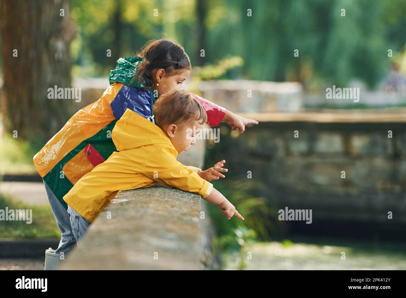 Looking at the river. Kids having fun outdoors in the park after the ...