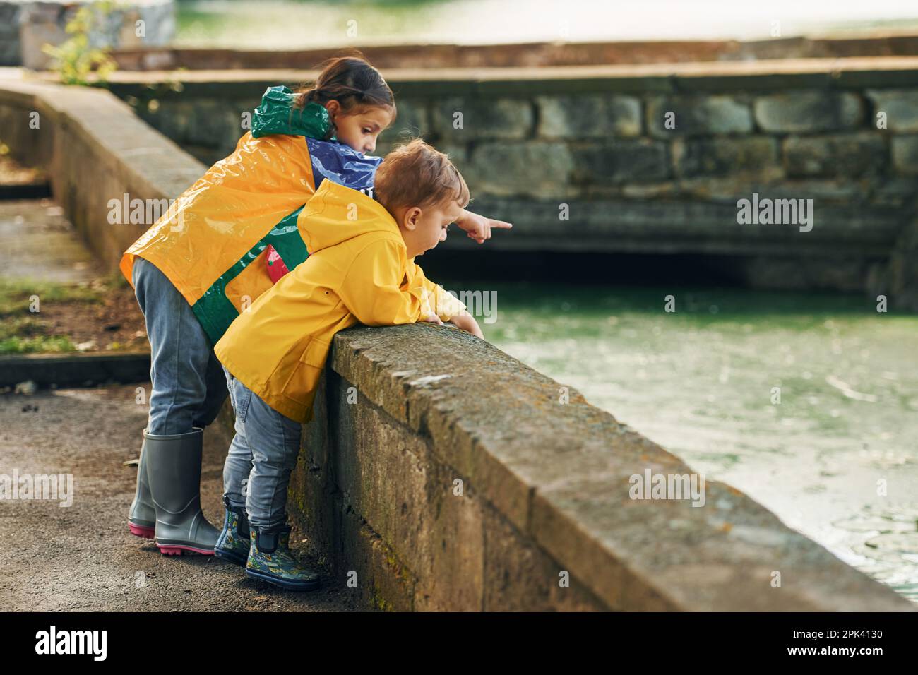Looking at the river. Kids having fun outdoors in the park after the ...