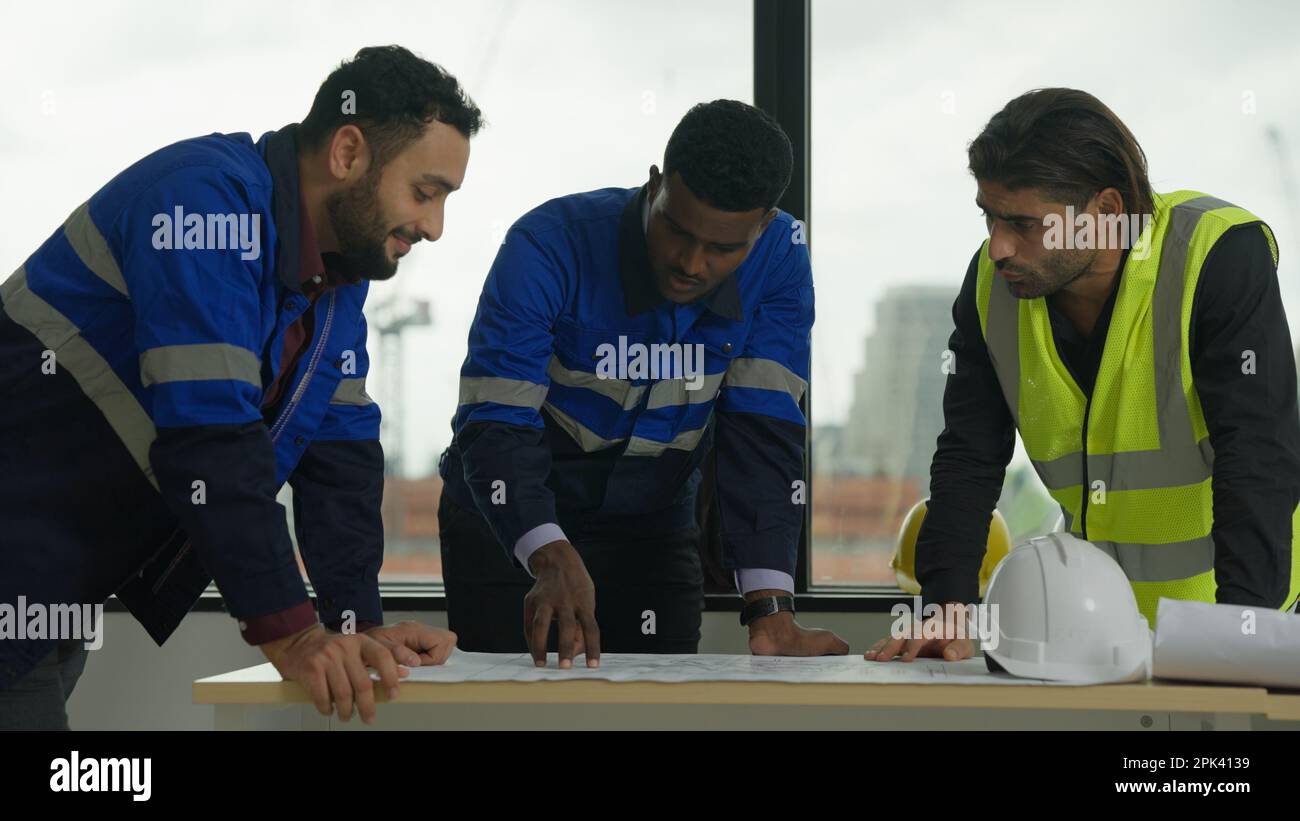 Construction engineers team using blueprint of project plan ...
