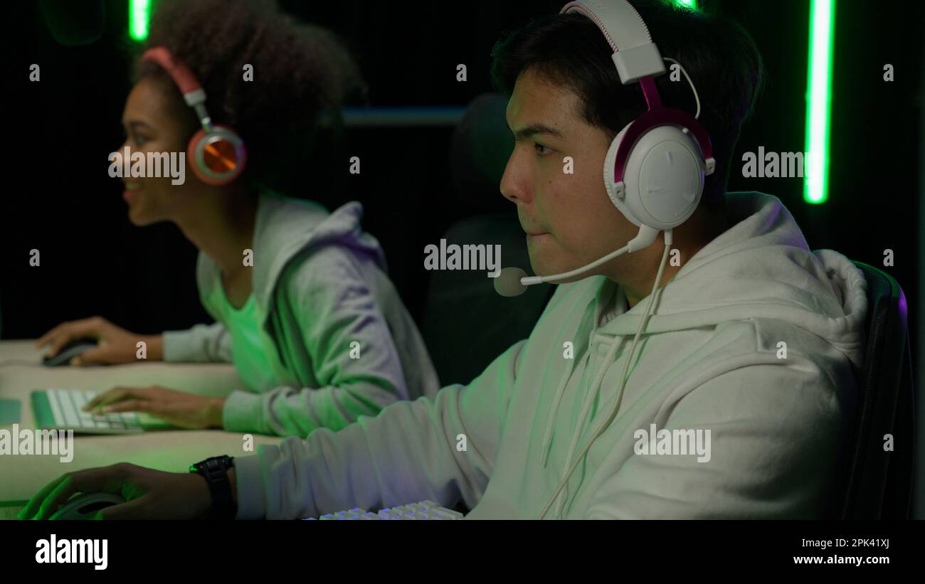 Game streamer using pc setup playing multiplayer first person shooter ...