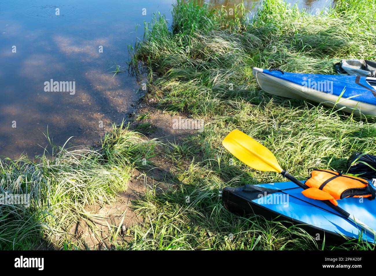 Tourist Canoes With Paddles Stand On The River Coast In Summer On A