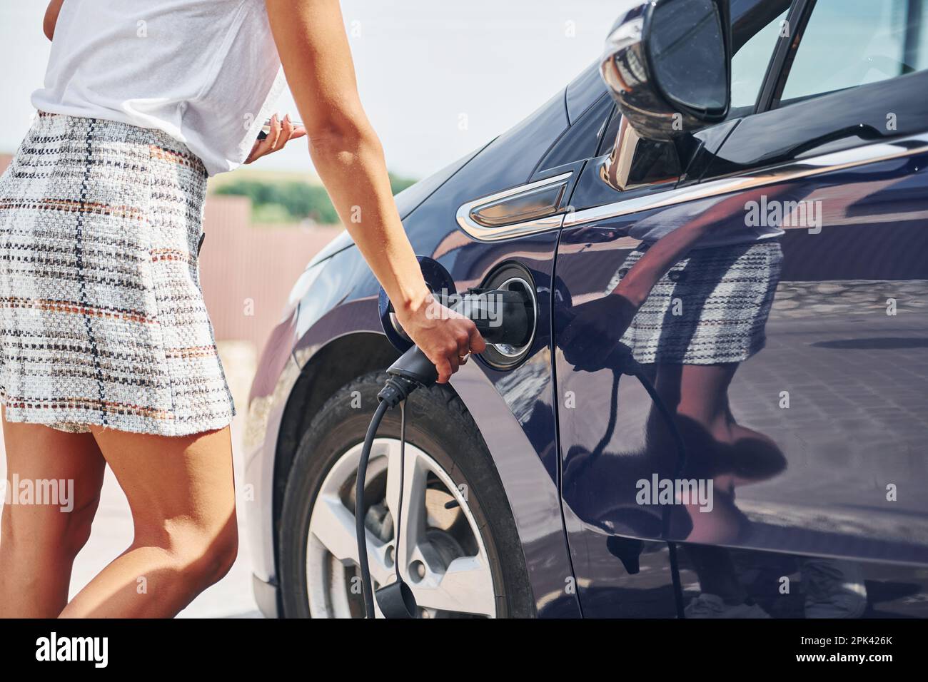 Charging the car. Woman is outdoors with her modern automobile Stock ...