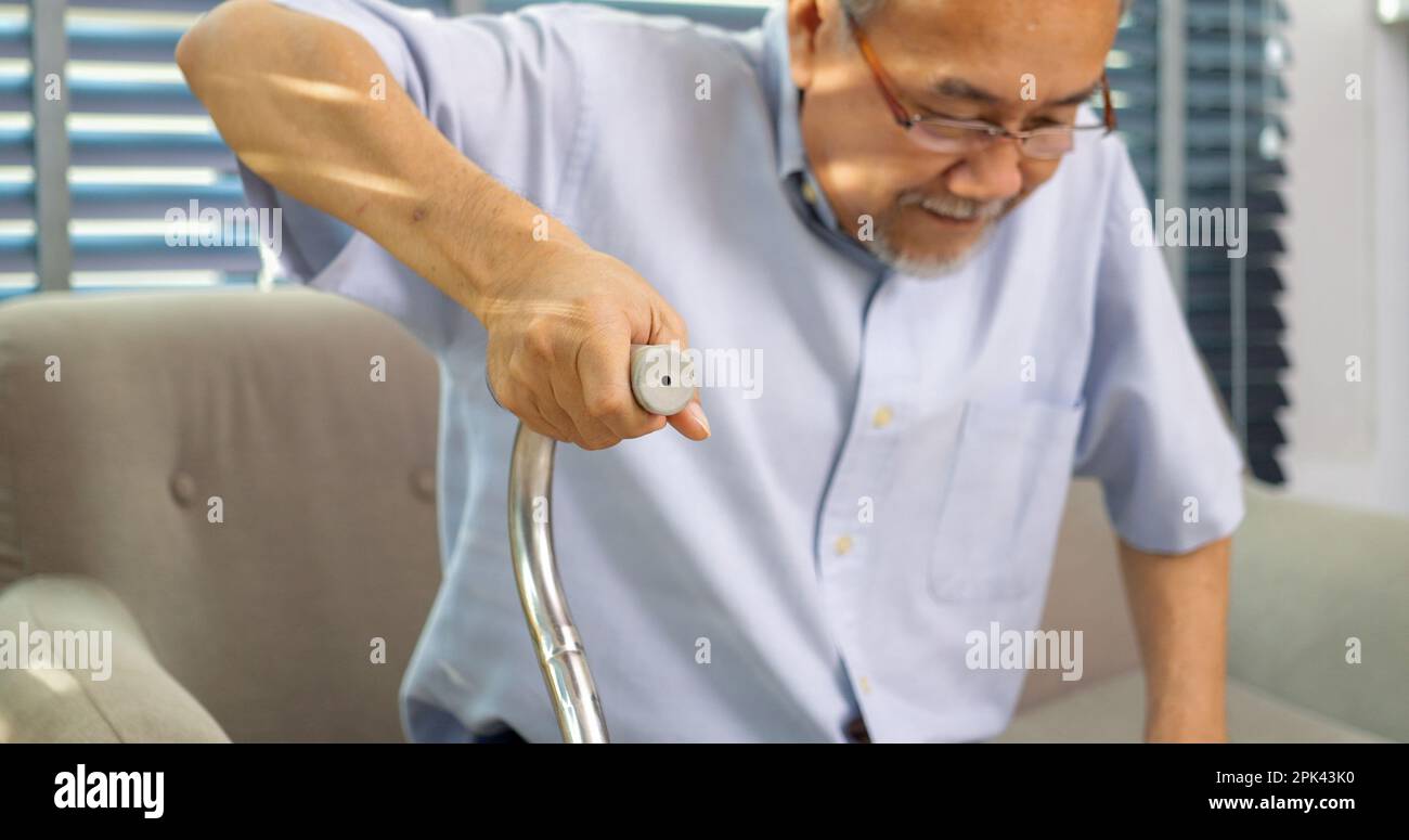 Close up hand of elderly man using walking stick trying to stand and ...
