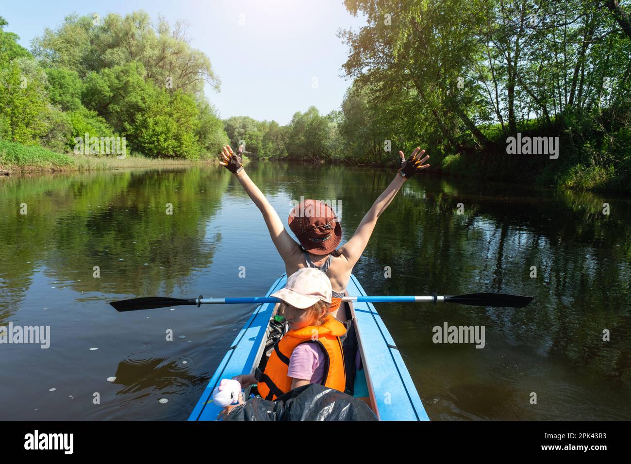 Family kayak trip. Mom and daughter rowing a boat on the river, a water ...