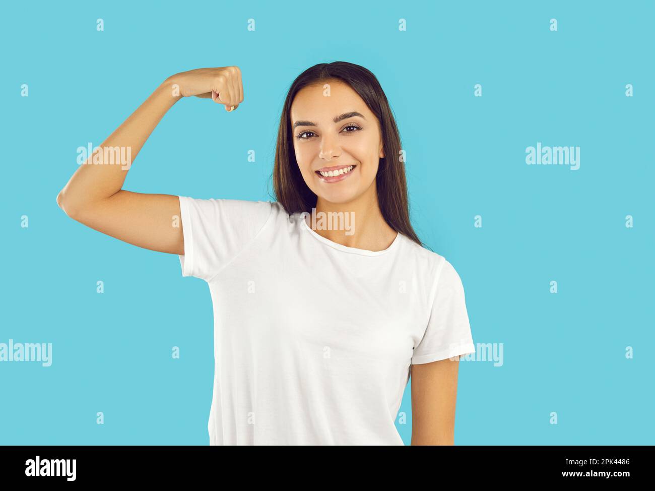 Happy beautiful young woman flexing arm to show that she is strong ...