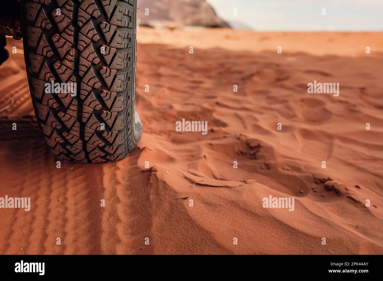 4wd vehicle tyre, dirty from dust - track print visible in red sand ...