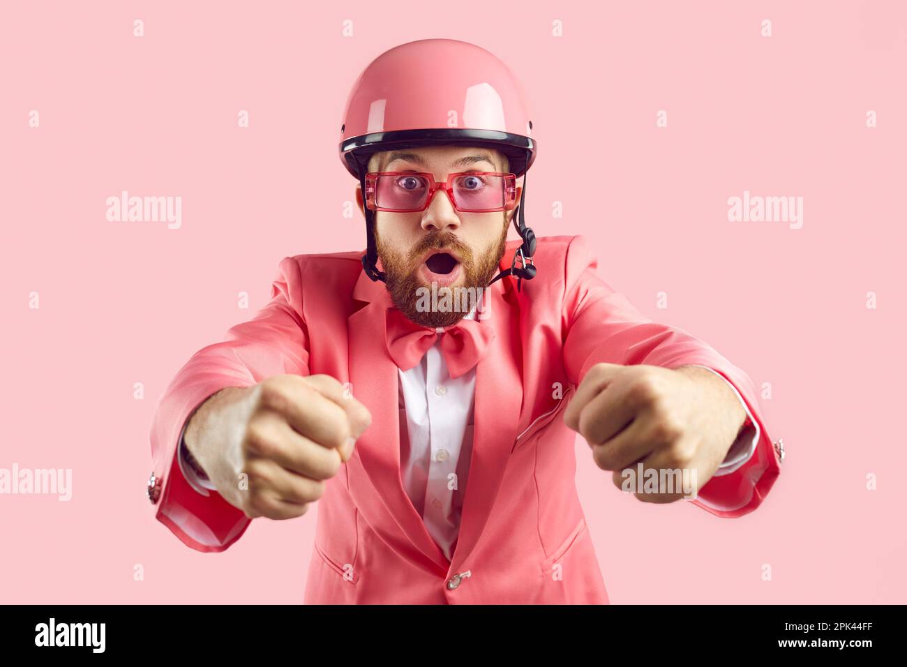 Funny surprised and scared man in pink helmet steering driving his ...