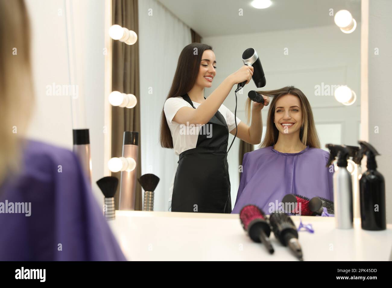 Stylist drying client's hair in beauty salon Stock Photo - Alamy