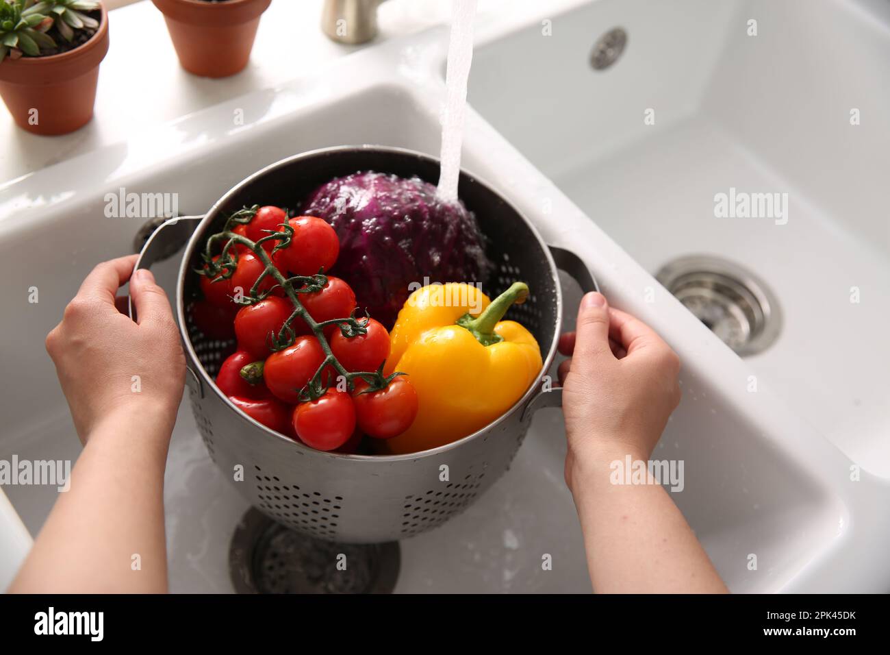 Woman washing fresh vegetables in kitchen sink, closeup Stock Photo - Alamy