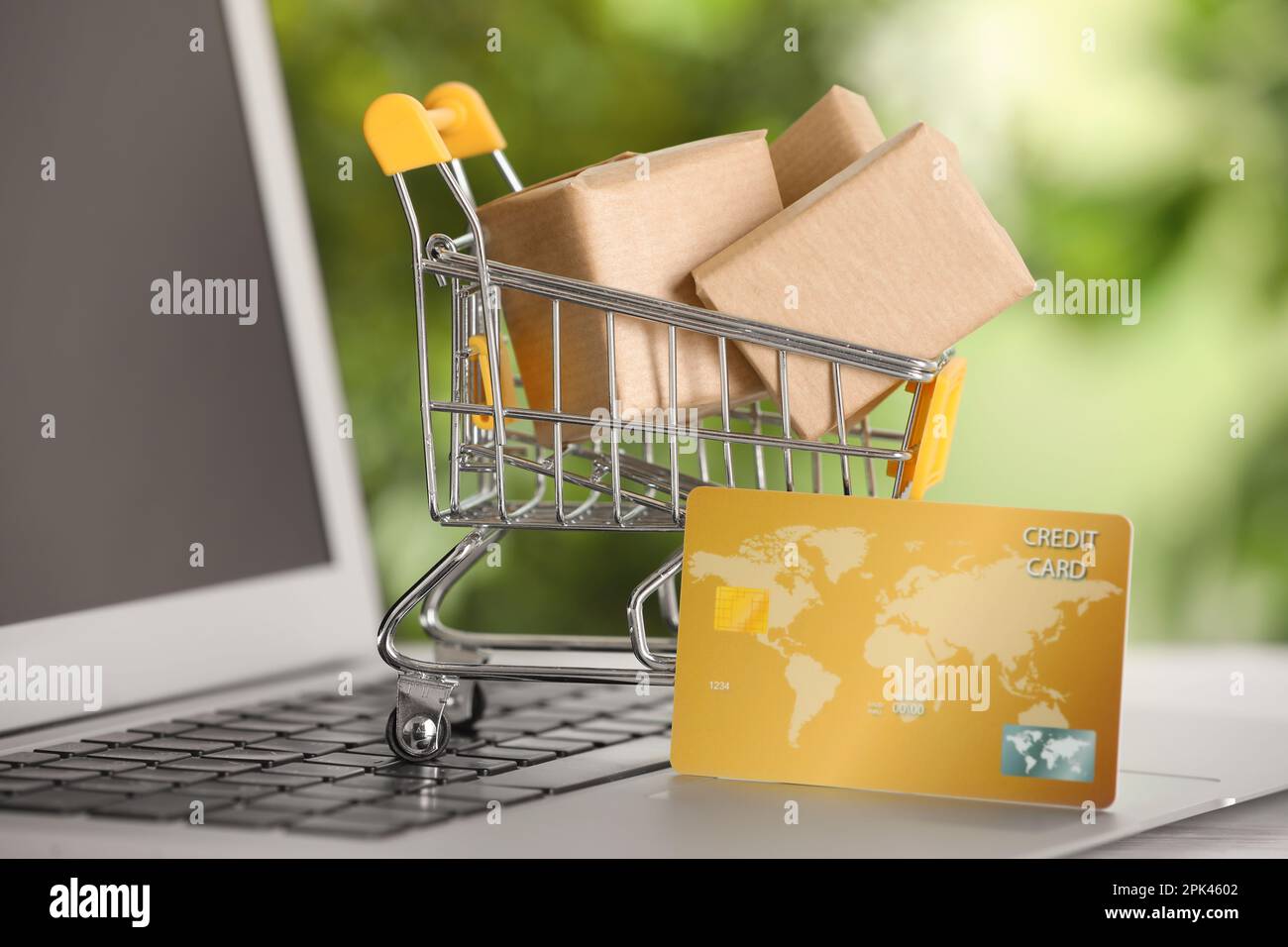 Online payment concept. Small shopping cart with bank card, boxes on ...