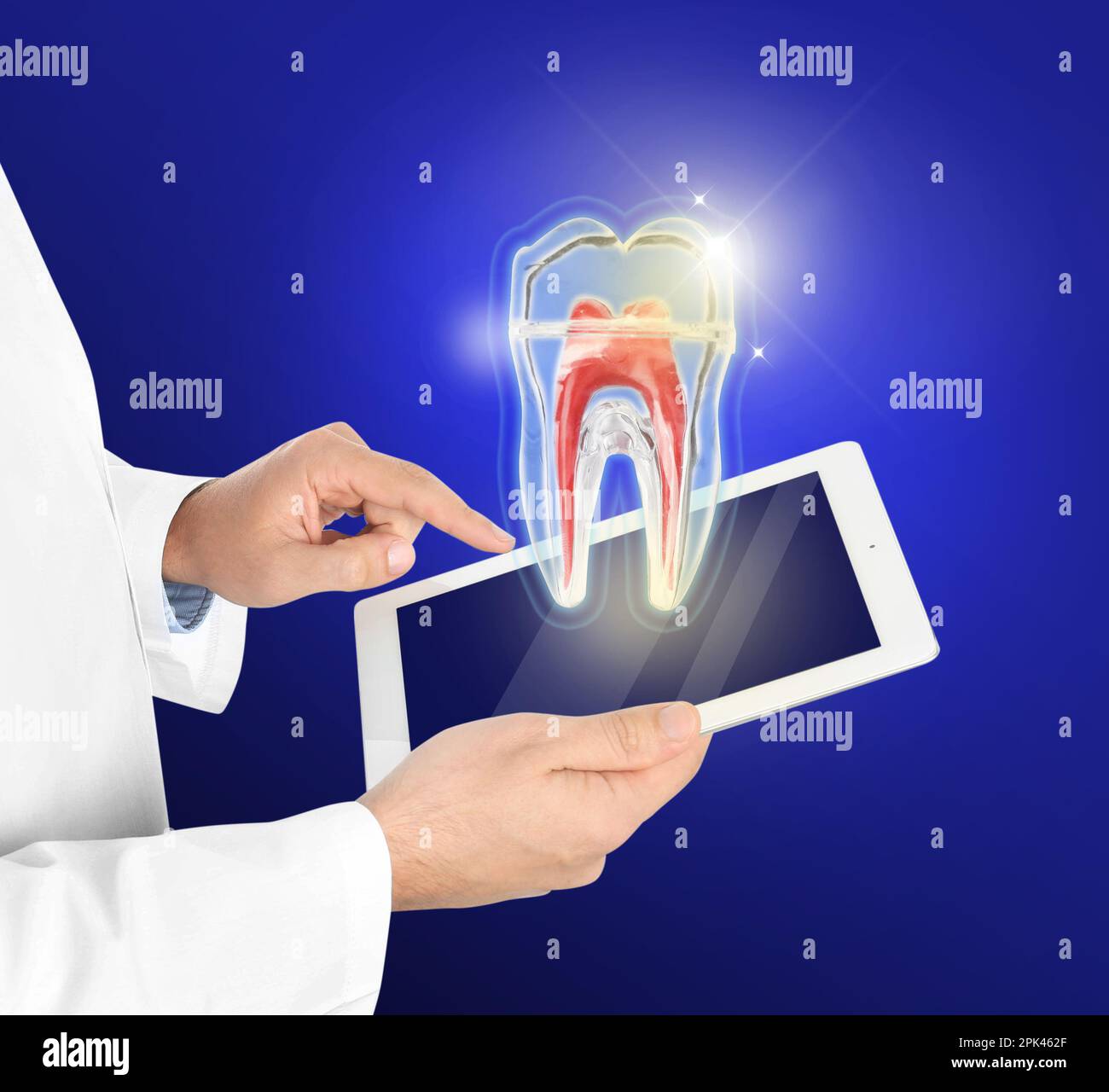 Dentist with tablet and virtual model of tooth on blue background ...