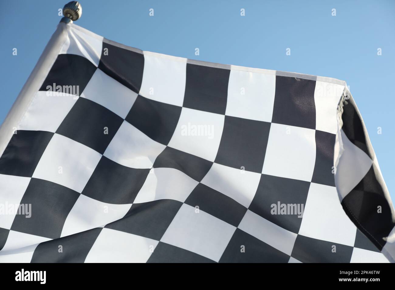 Checkered finish flag on light blue background, closeup Stock Photo - Alamy