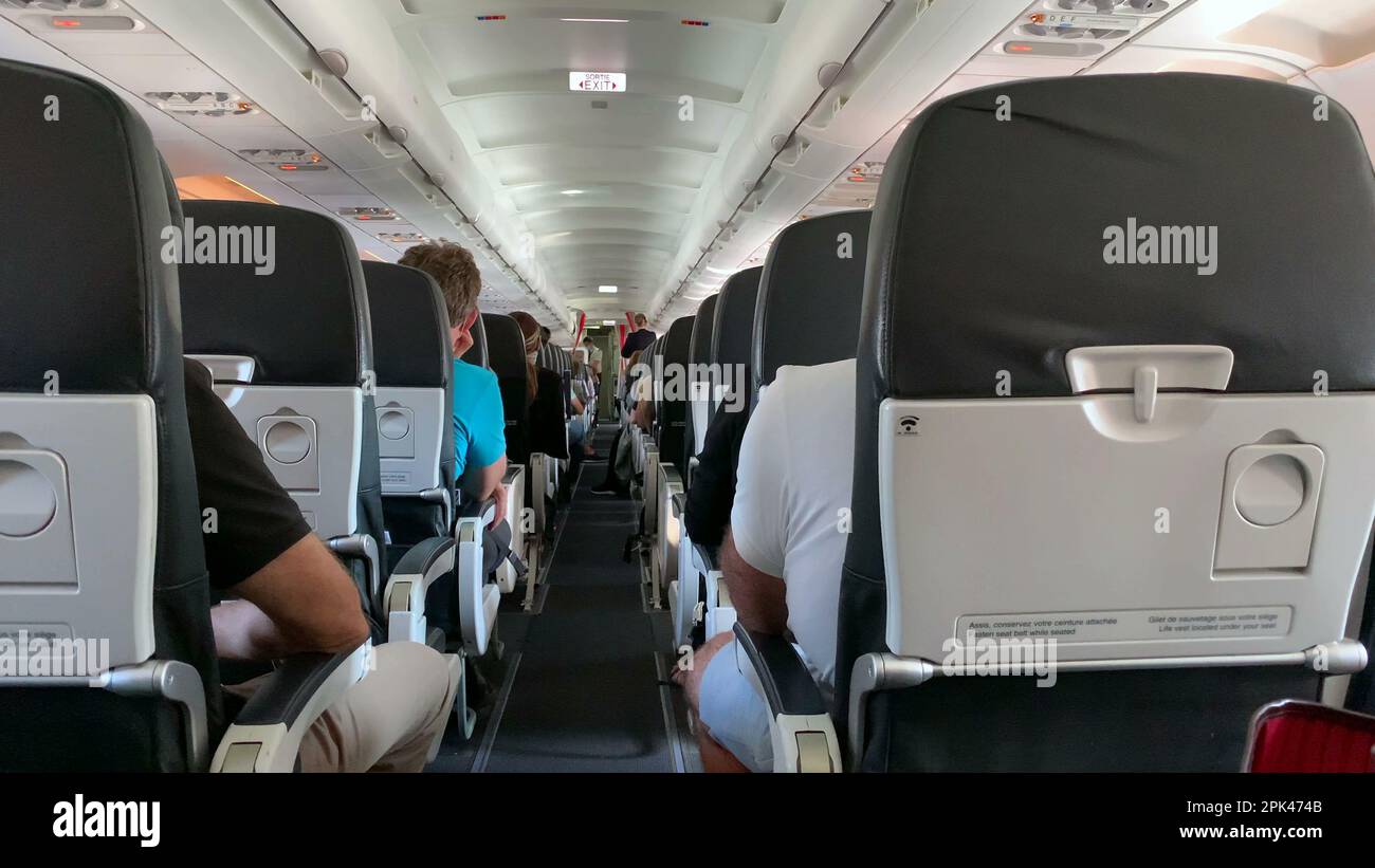 Back of airplane interior. passenger perspective in plane corridor ...