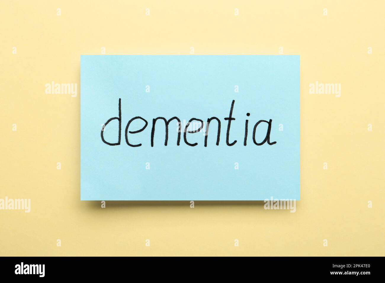 Paper note with word Dementia on beige background, top view Stock Photo ...