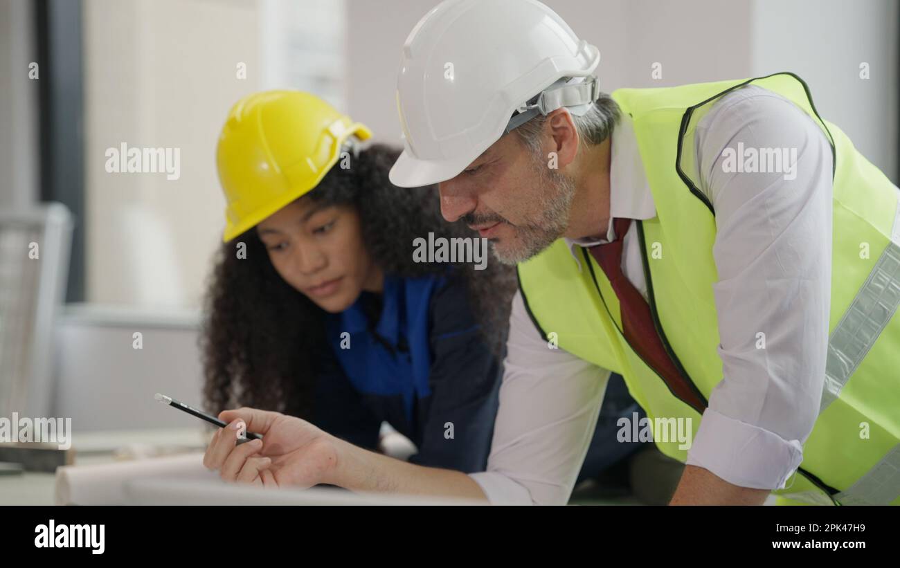 Professional construction engineers team using blueprint of project ...