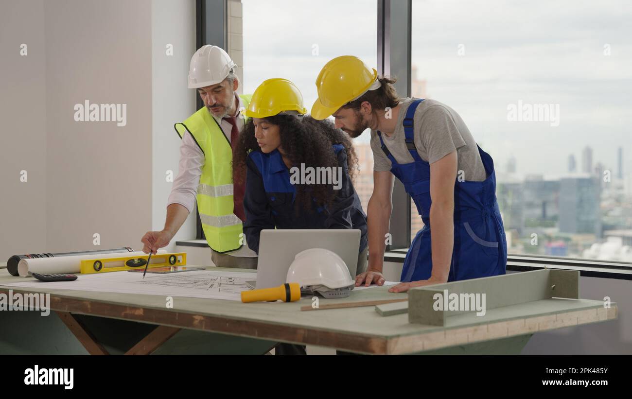 Professional construction engineers team using blueprint of project ...